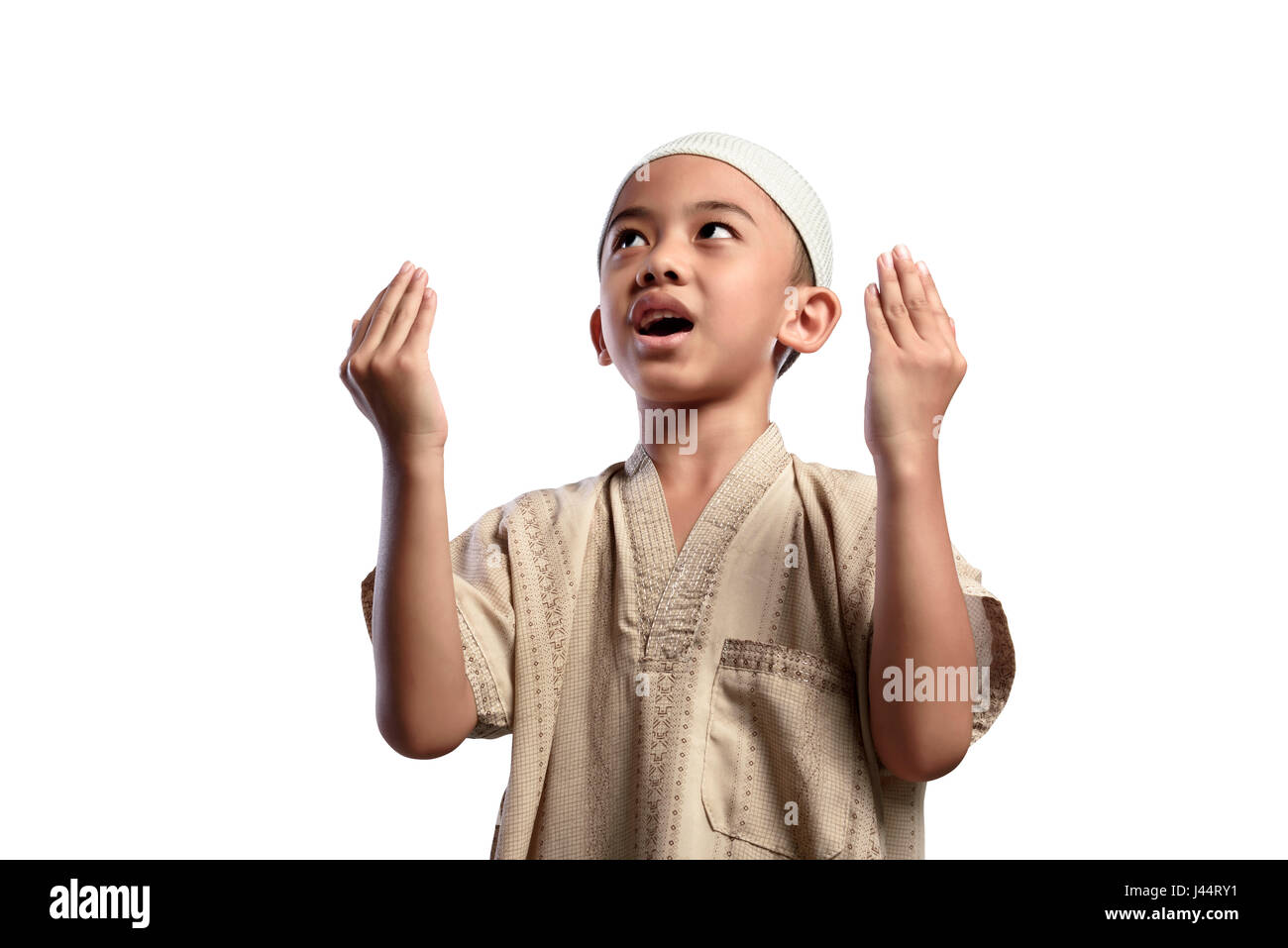 Asian muslim kid with white cap praying to god isolated over white ...