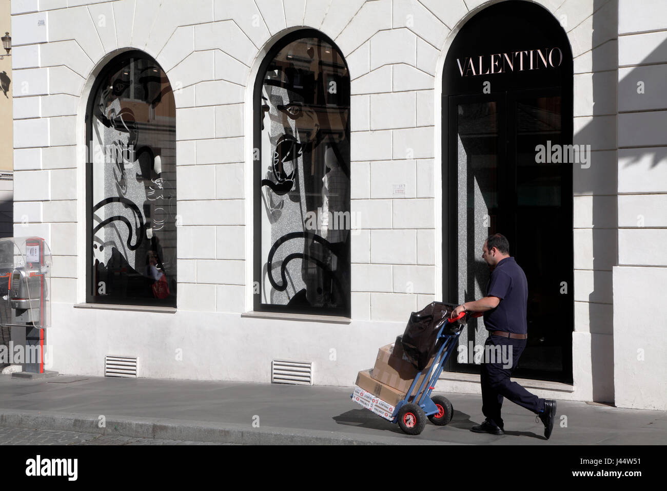 Pedestrian walk past of a Valentino store at Piazza Mignanelli, Rome ...