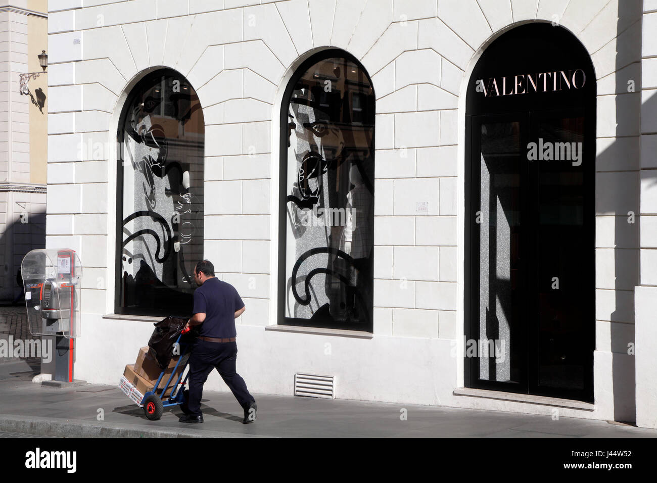 Pedestrian walk past of a Valentino store at Piazza Mignanelli, Rome ...