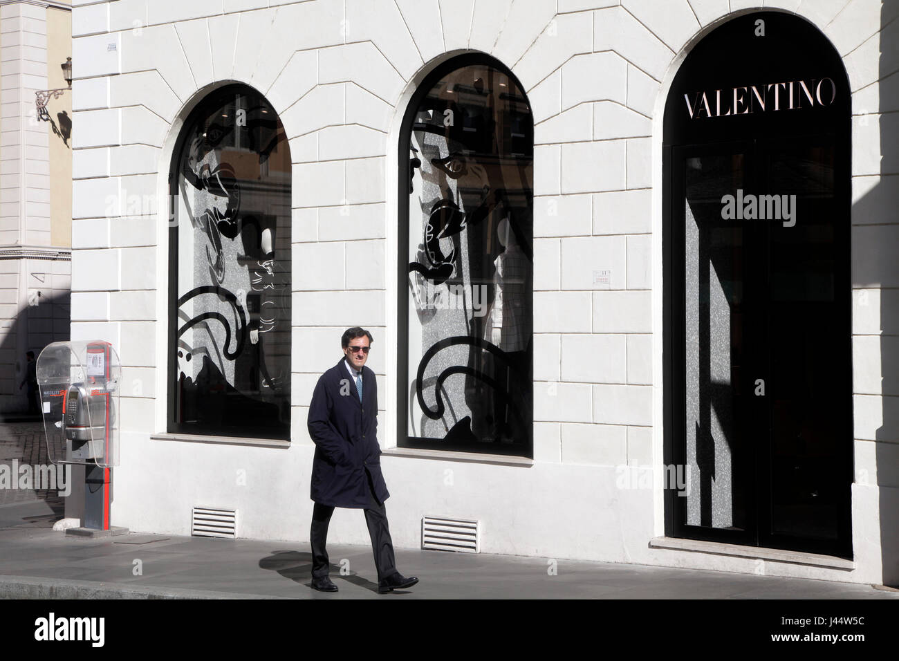 Pedestrian walk past of a Valentino store at Piazza Mignanelli, Rome ...