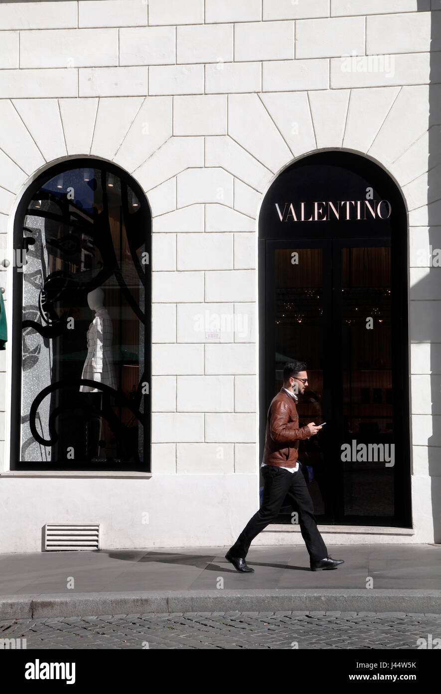 Pedestrian walk past of a Valentino store at Piazza Mignanelli, Rome ...
