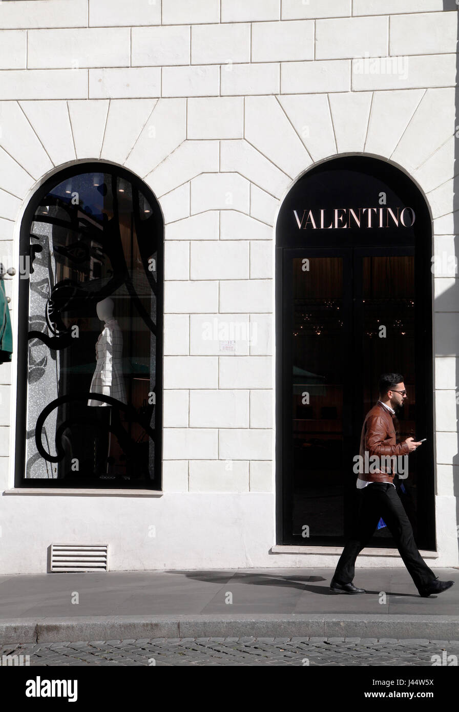 Pedestrian walk past of a Valentino store at Piazza Mignanelli, Rome ...