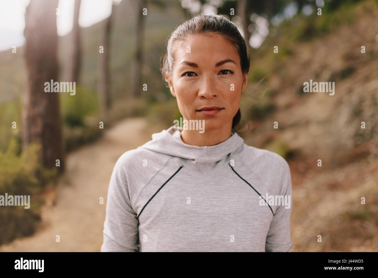 Portrait of healthy young asian woman standing outdoors. Woman runner ...