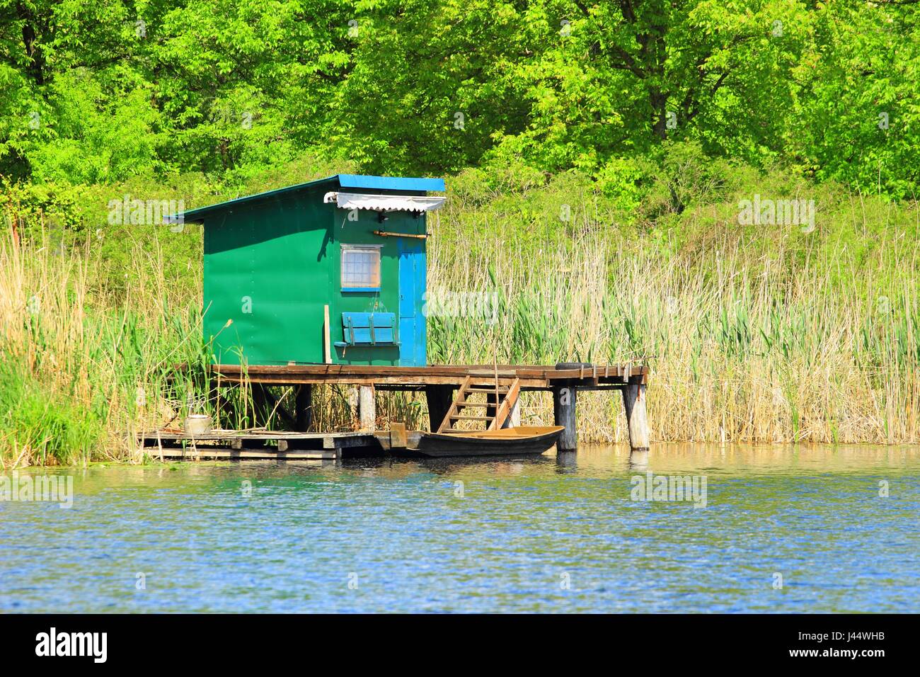 Small house for fishing with wooden boat on the lake coast Stock Photo ...