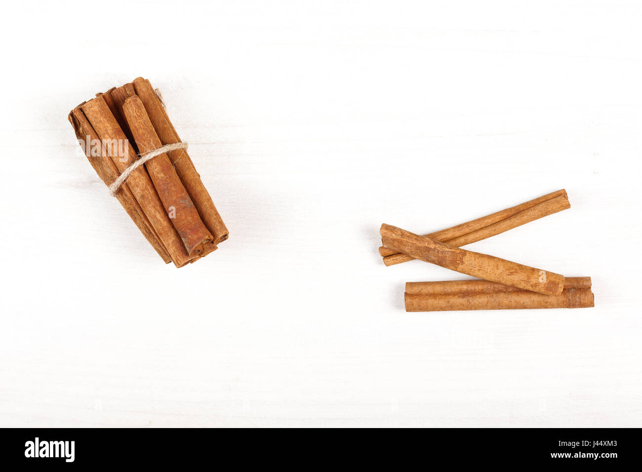 Cinamon sticks with cocoa powder, little spoon and herbs on white ...