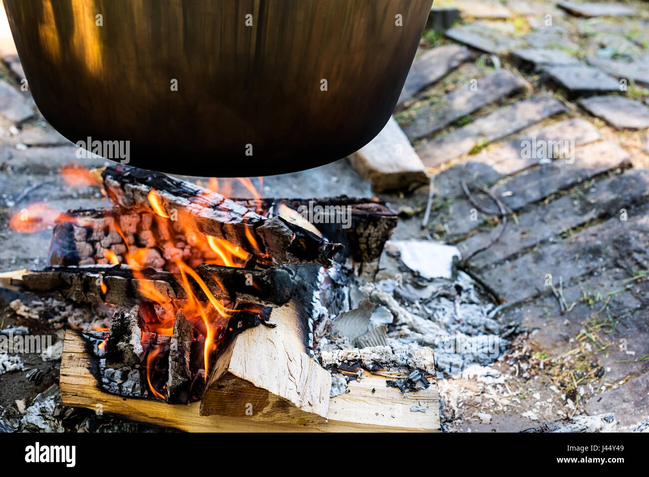 Cooking food on fire outdoors. Cooking outdoors in cast-iron cauldron ...