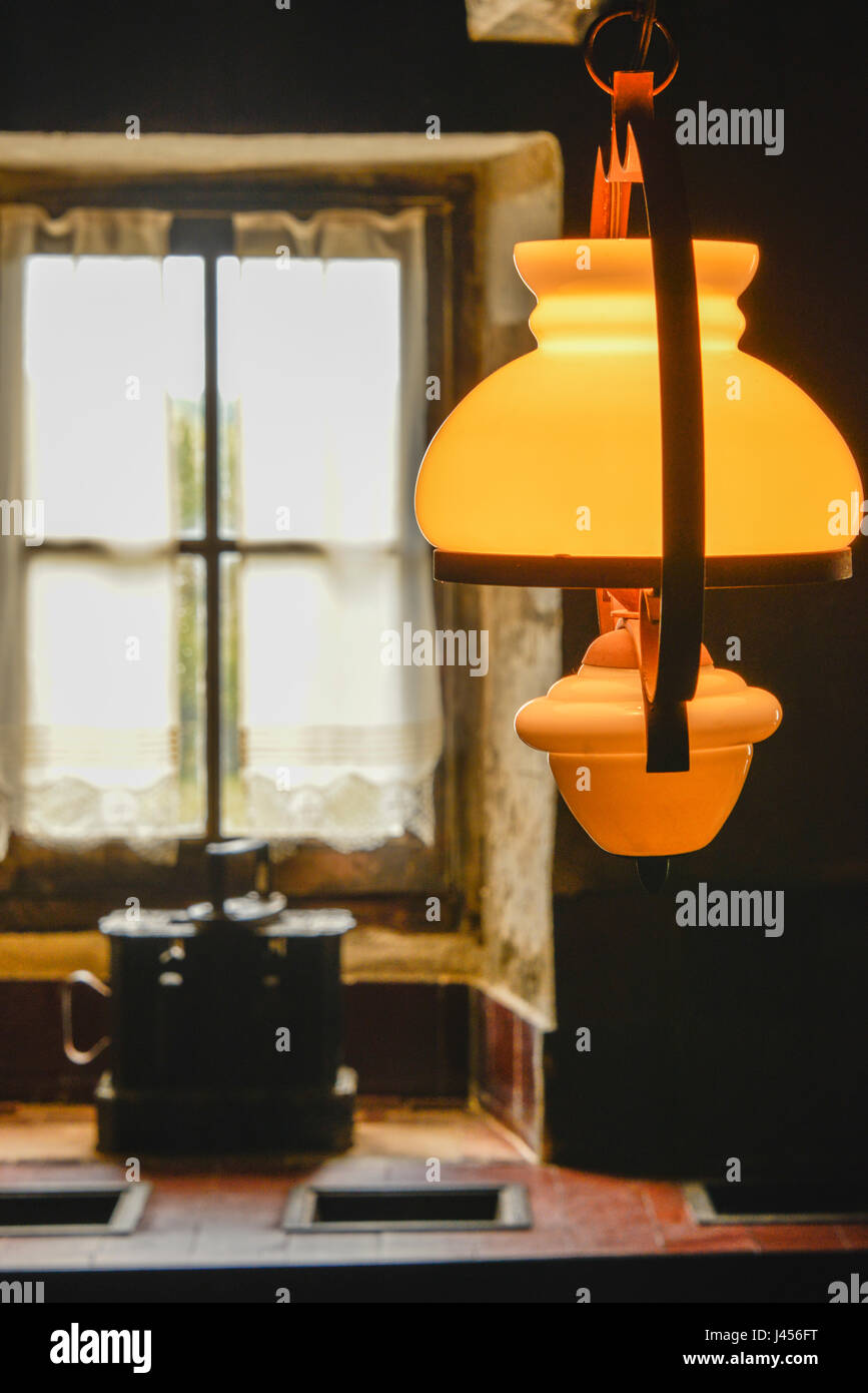 Portrait view of an illuminated gas lantern, with daylight entering ...
