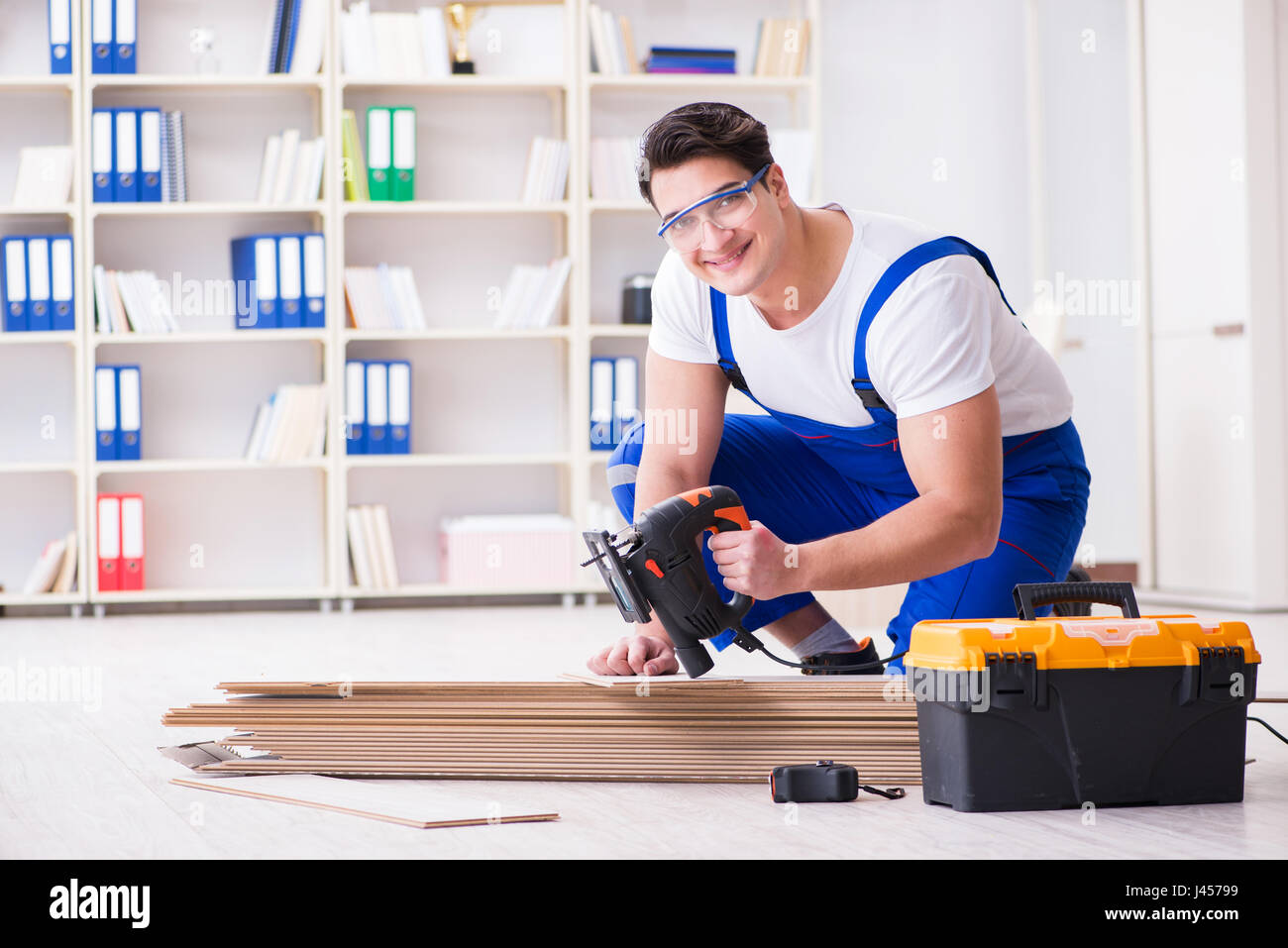 Young worker working on floor laminate tiles Stock Photo - Alamy