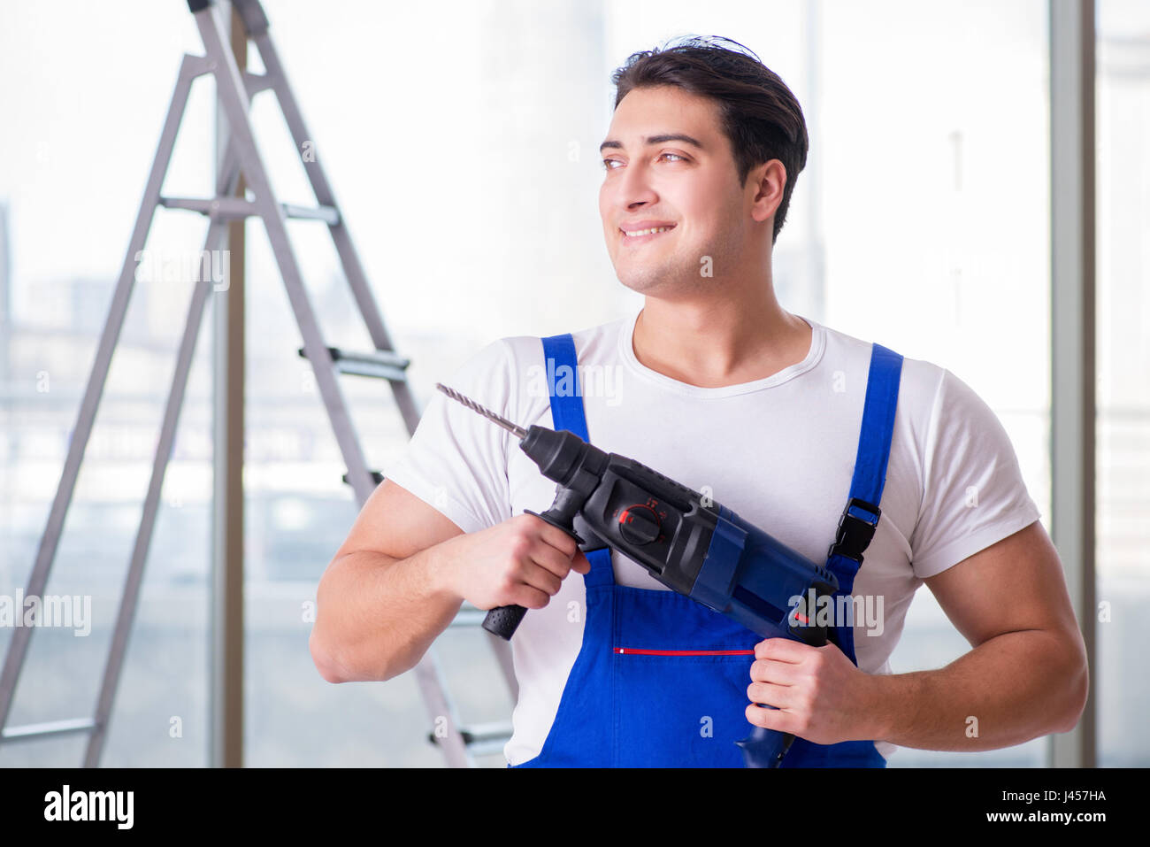 Young worker with hand drill Stock Photo - Alamy