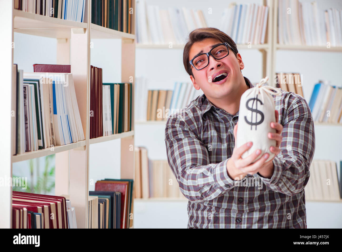 Young student in expensive textbooks concept Stock Photo - Alamy