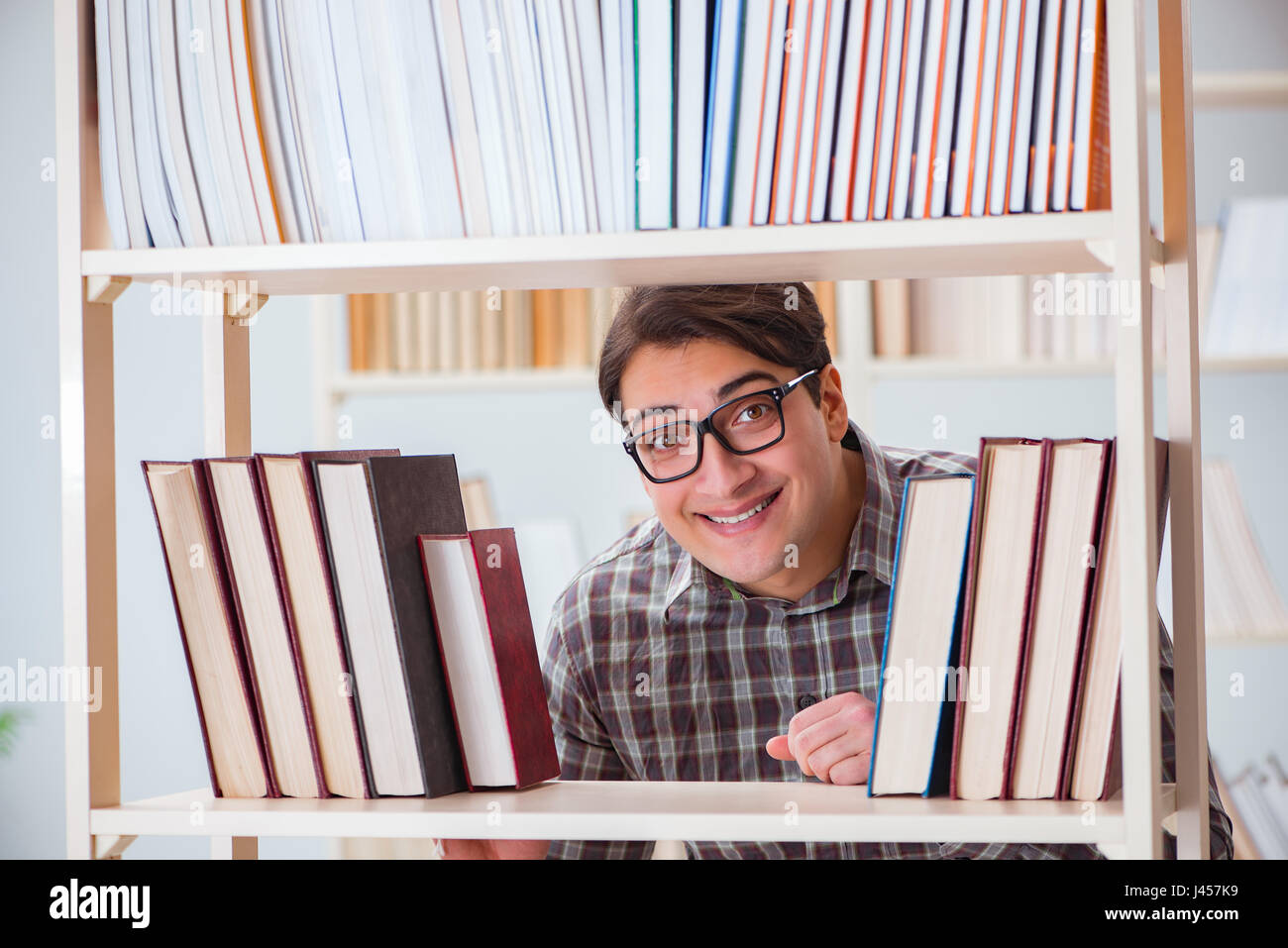 Young student looking for books in college library Stock Photo - Alamy