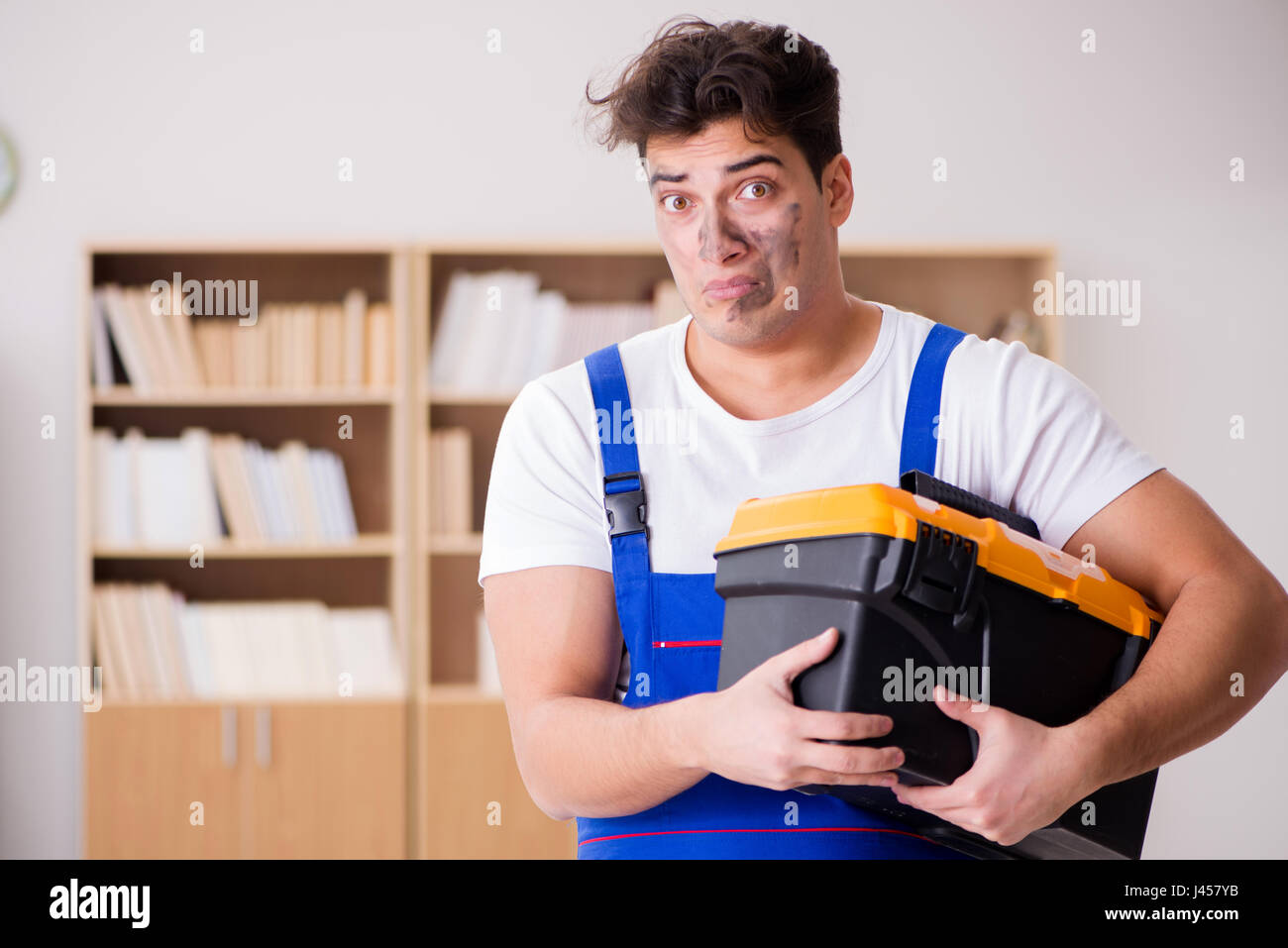 Funny worker with dirty face and toolkit Stock Photo - Alamy