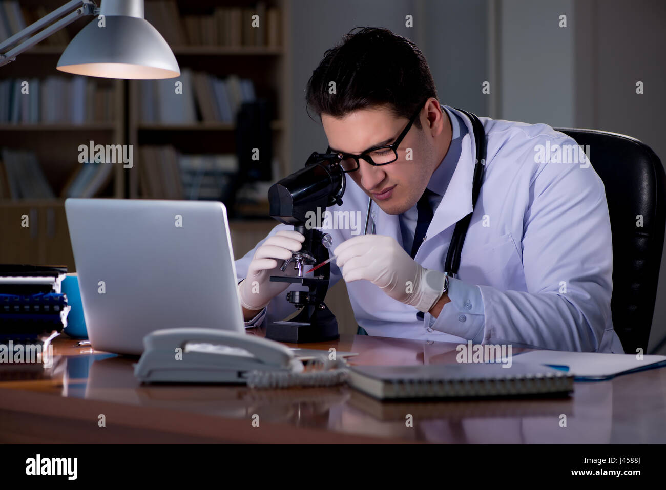 Young doctor working late in the office Stock Photo - Alamy