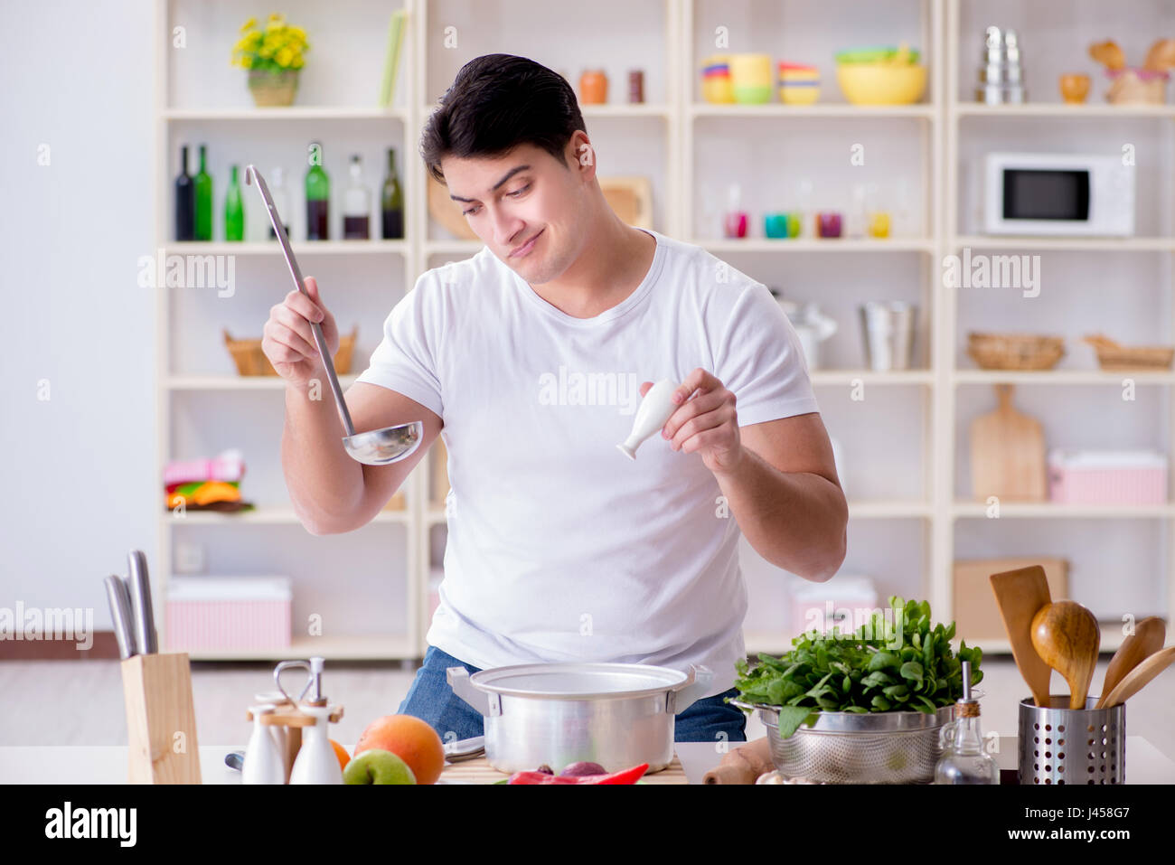 Young male cook working in the kitchen Stock Photo - Alamy