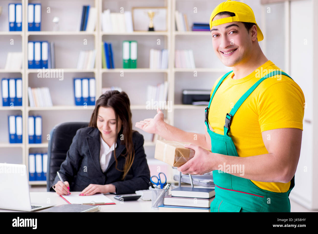 Postman delivering parcel to the office Stock Photo - Alamy