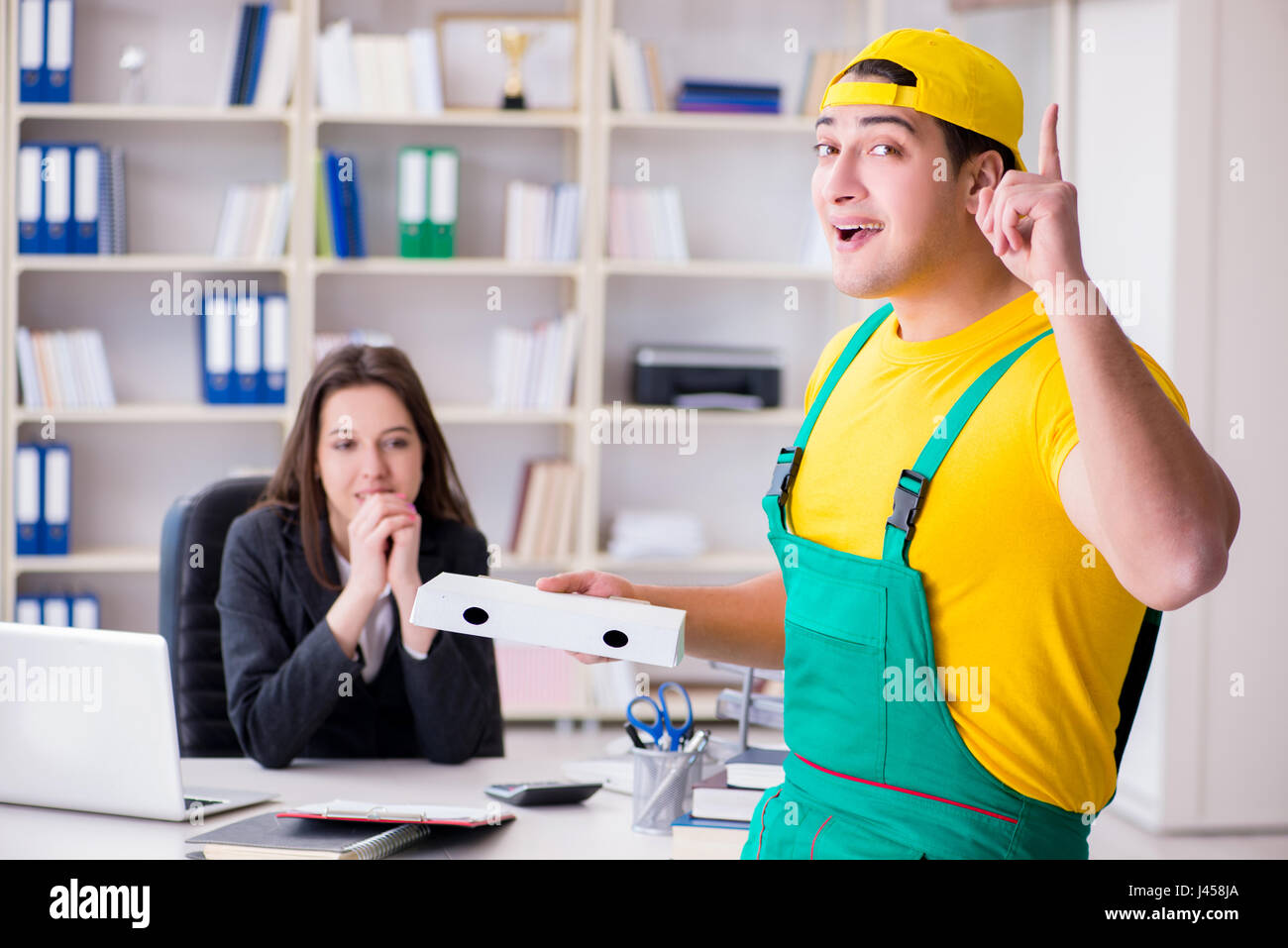Postman delivering parcel to the office Stock Photo - Alamy