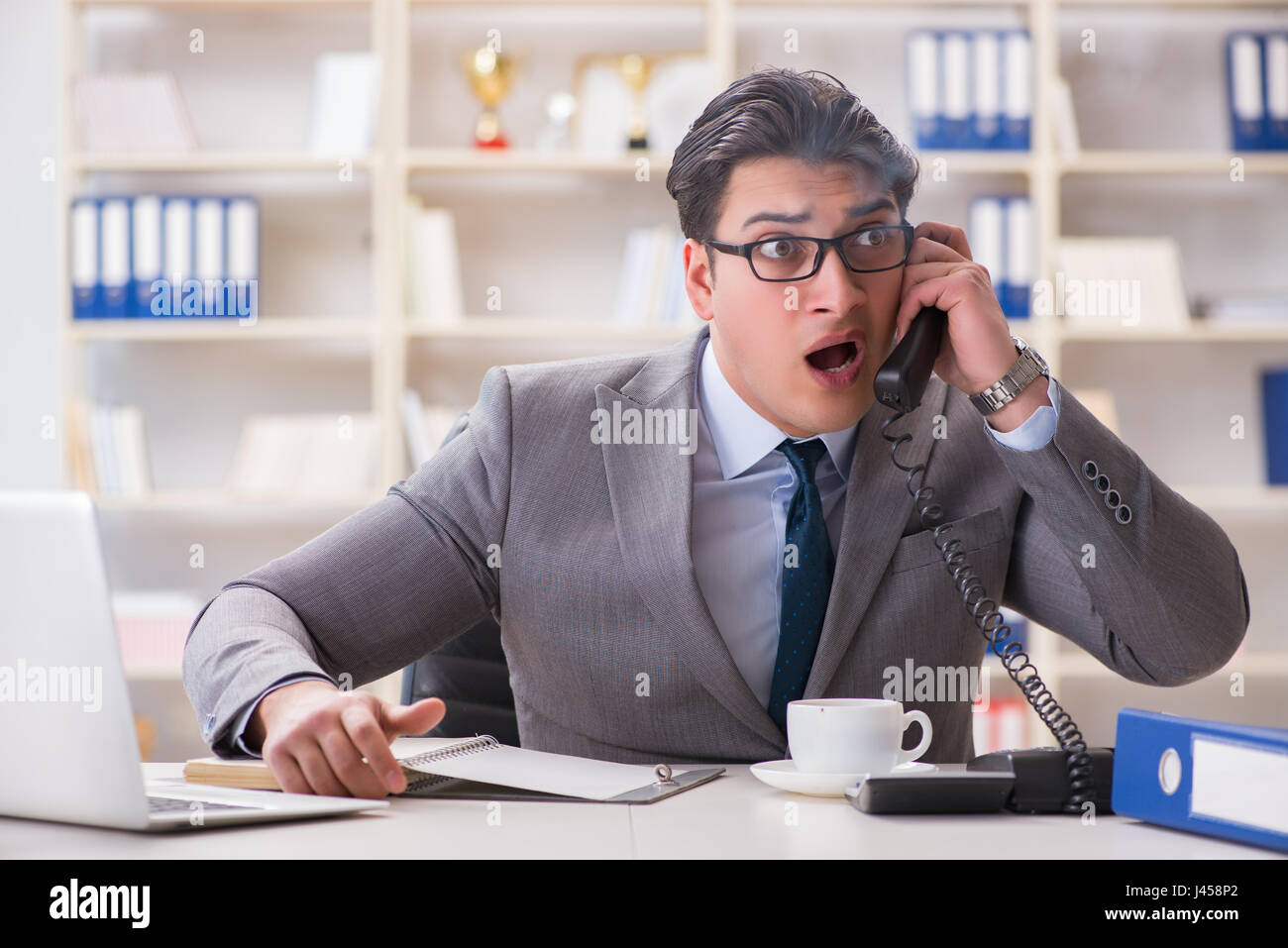 Businessman during fire alarm in office Stock Photo - Alamy