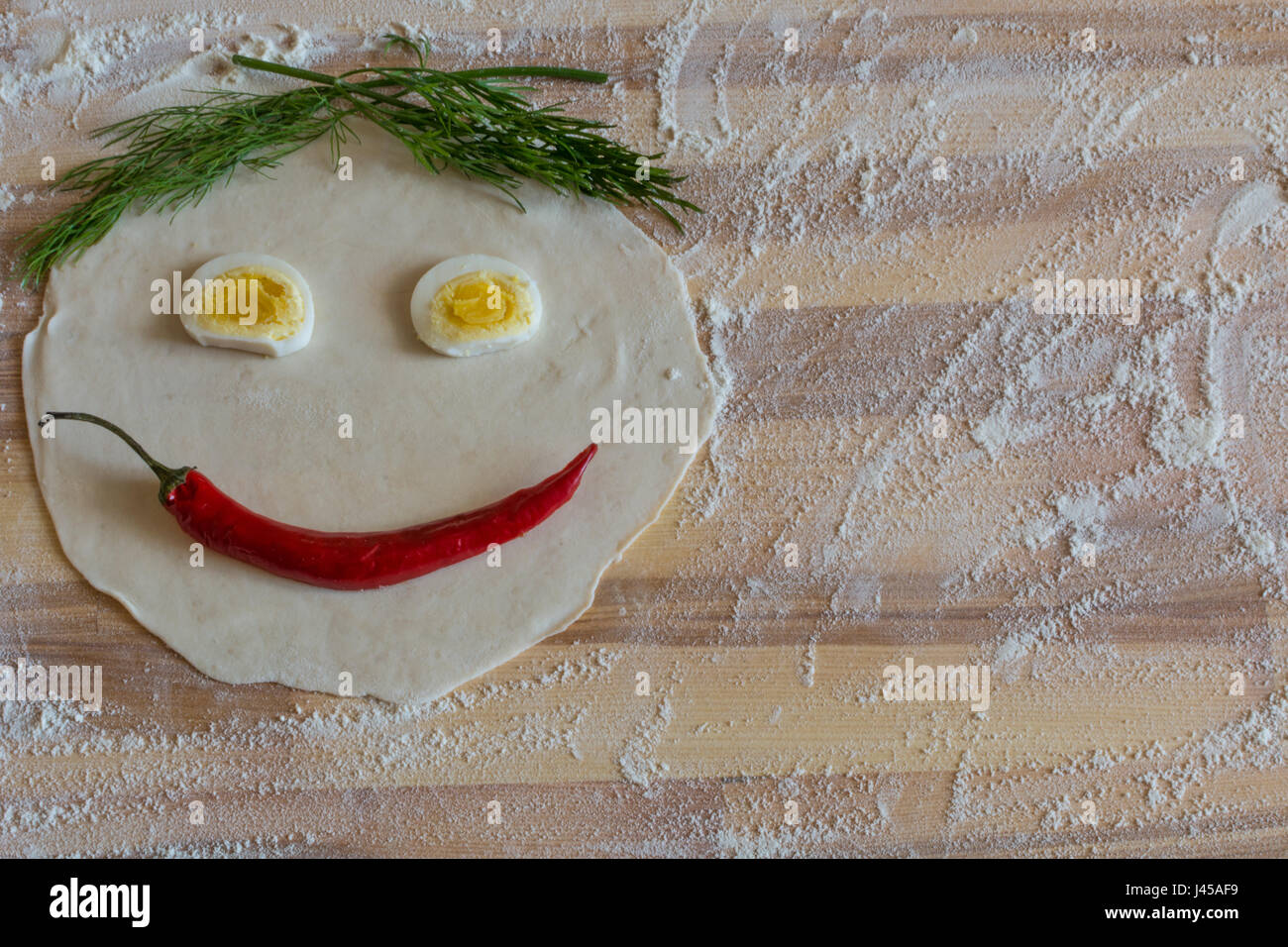 Bakery background, face of dough with eyes from boiled eggs, mouth of ...