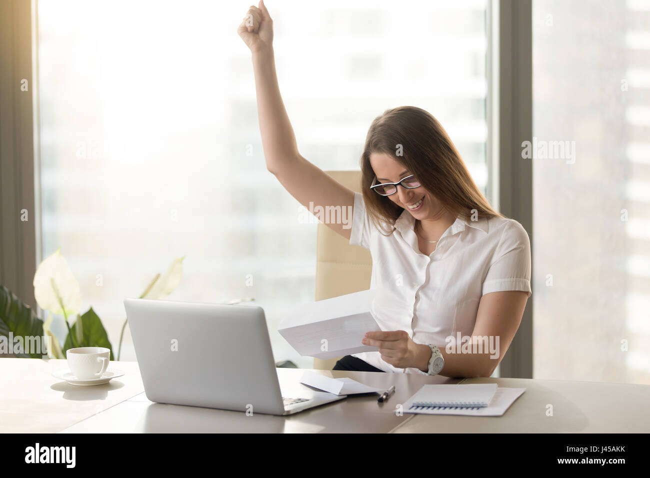 Happy businesswoman reading letter in office Stock Photo - Alamy