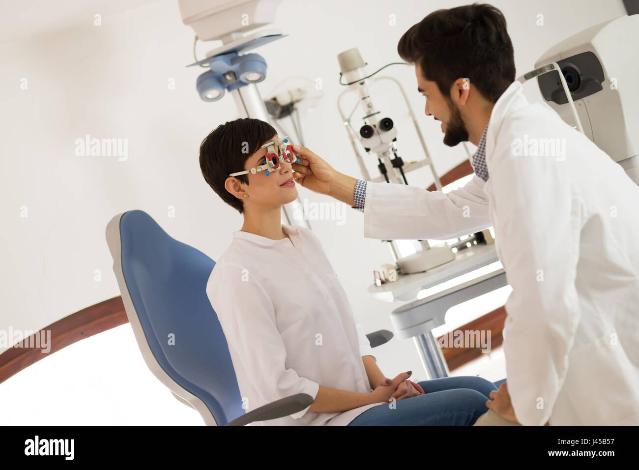 Optometrist examining patient in ophthalmology clinic with professional ...