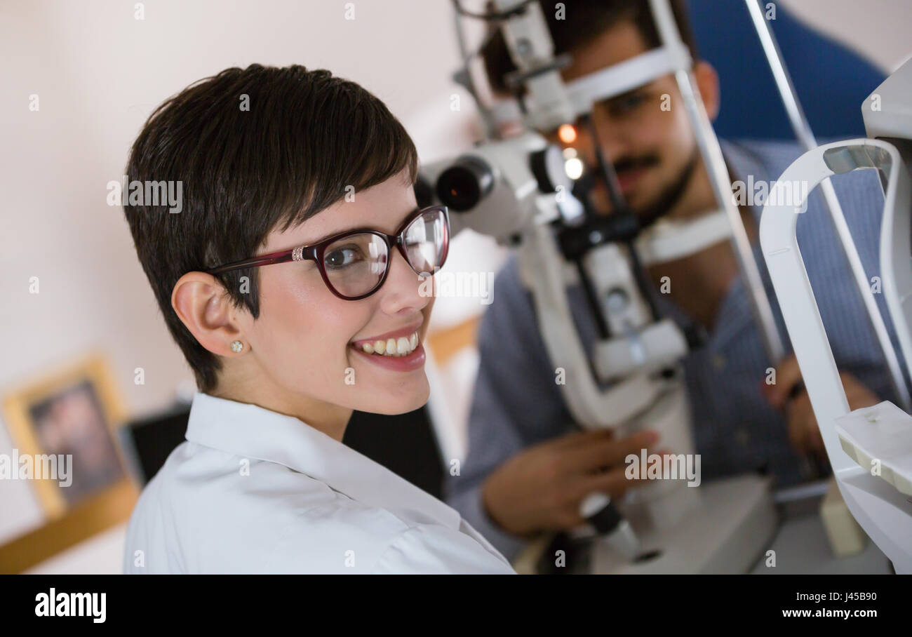 Optometrist examining patient in ophthalmology clinic with professional ...