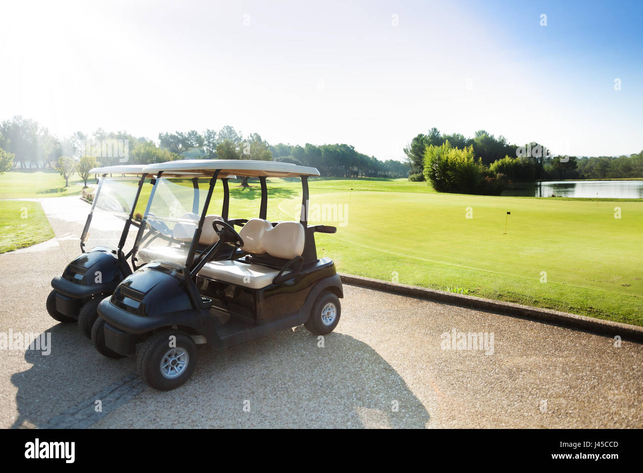 Two golf-carts standing at parking of golf club Stock Photo - Alamy