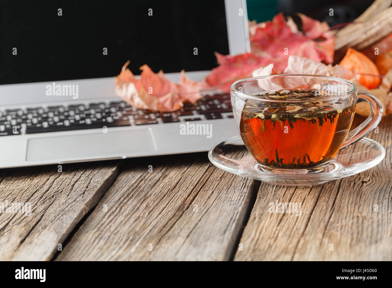 Cup of herbal tea on table with laptop Stock Photo - Alamy