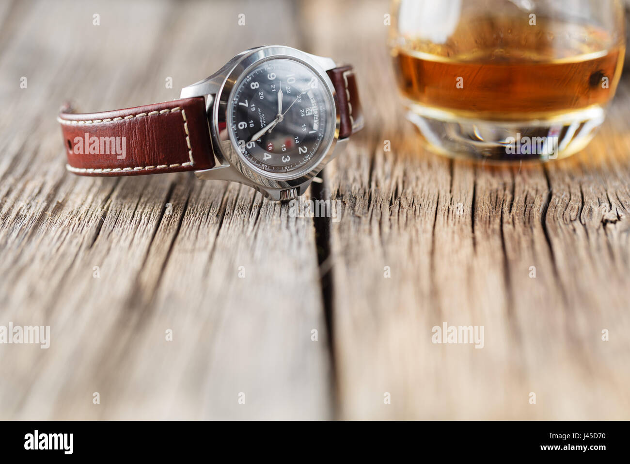 Whiskey glass with watch Stock Photo - Alamy