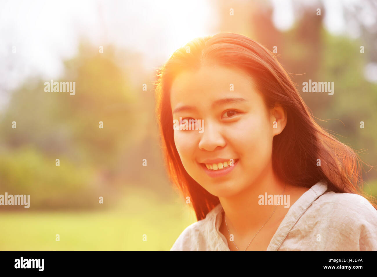 Portrait of pretty Asian girl. Sunrise grass shooting Stock Photo - Alamy
