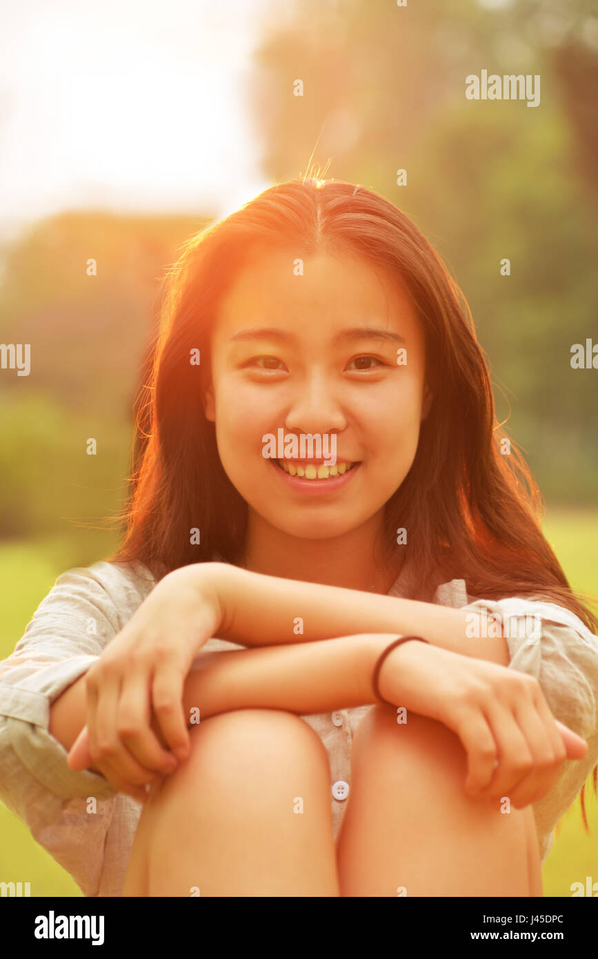 Portrait of pretty Asian girl. Sunrise grass shooting Stock Photo - Alamy