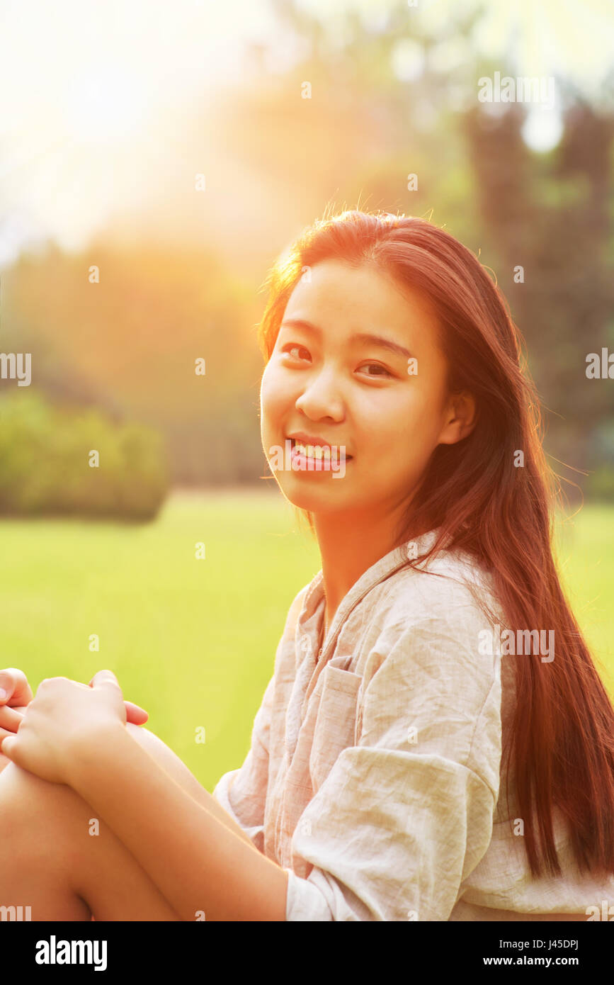 Portrait of pretty Asian girl. Sunrise grass shooting Stock Photo - Alamy