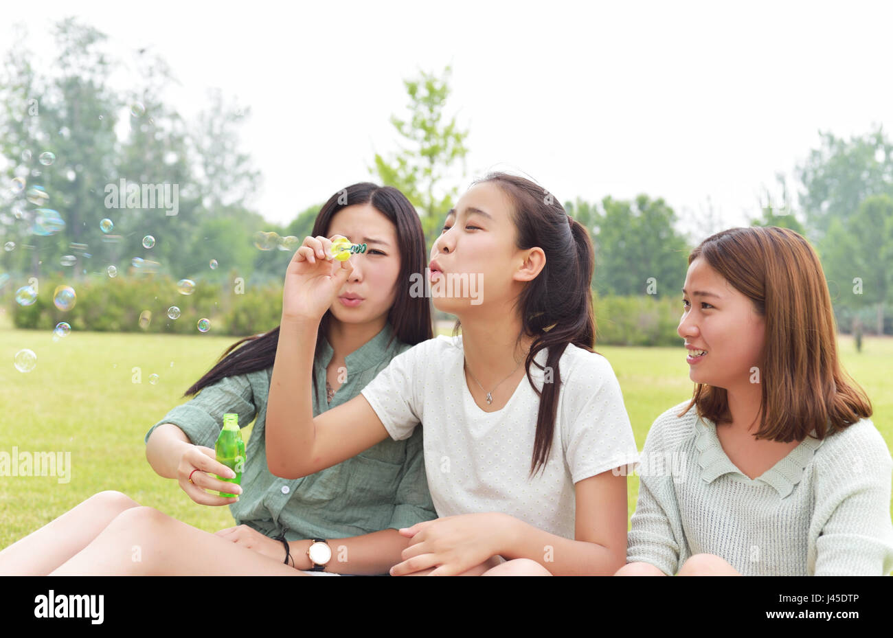 Bubble blowing three female students. At Park Meadows Stock Photo - Alamy