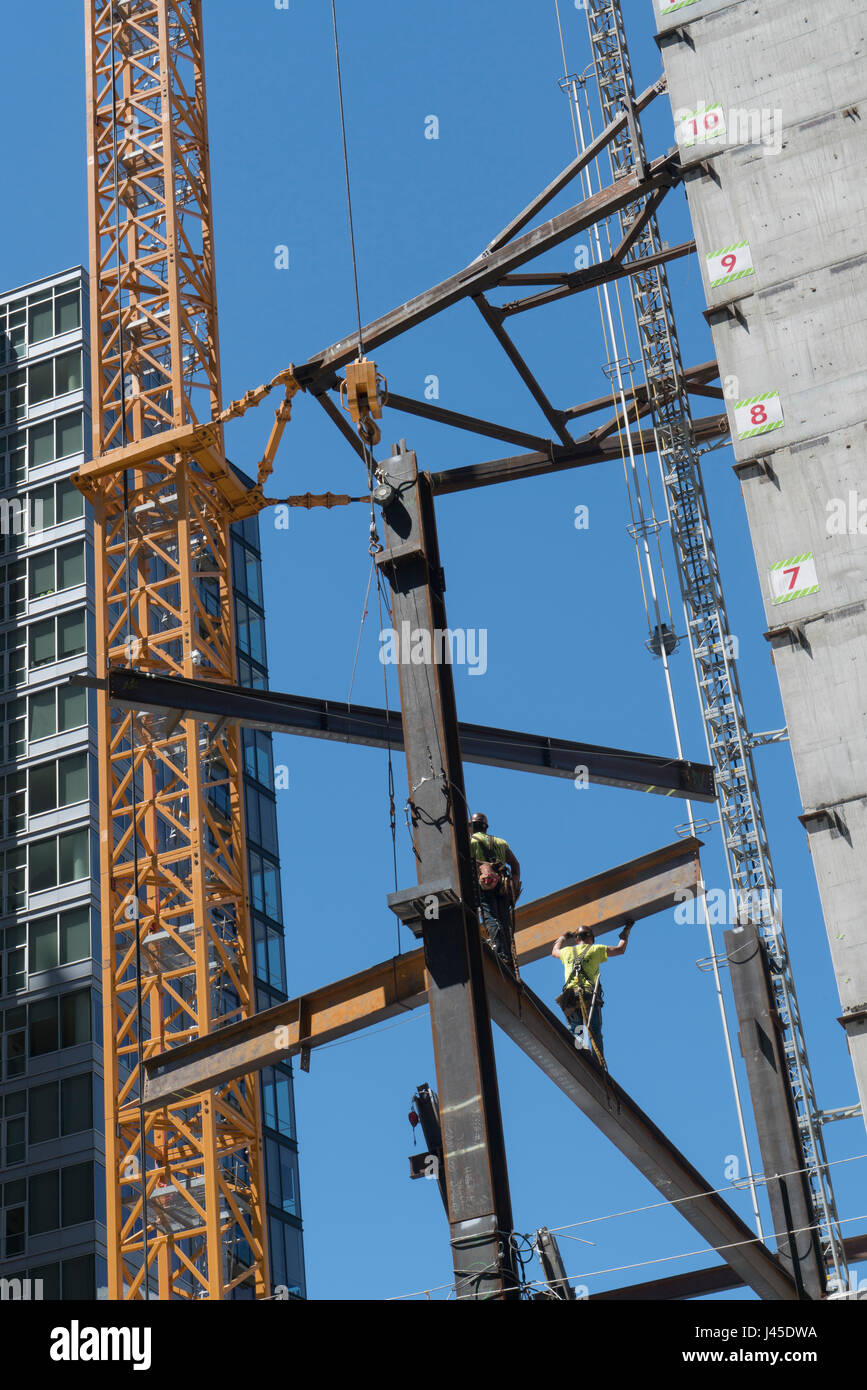 United States, Washington, Seattle, Workers putting up iron frame while ...