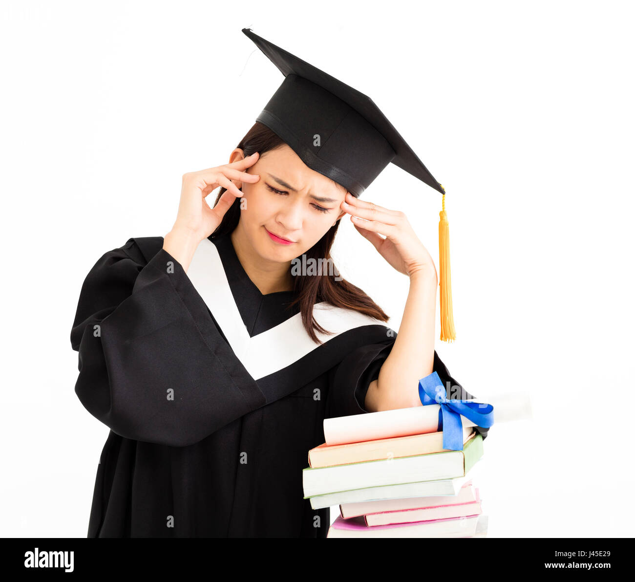 Upset graduate student with stack of books Stock Photo - Alamy