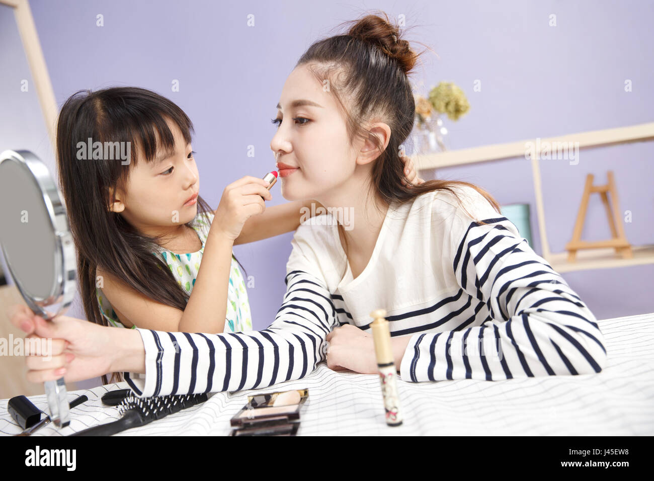 The little girl make up for her mother Stock Photo - Alamy