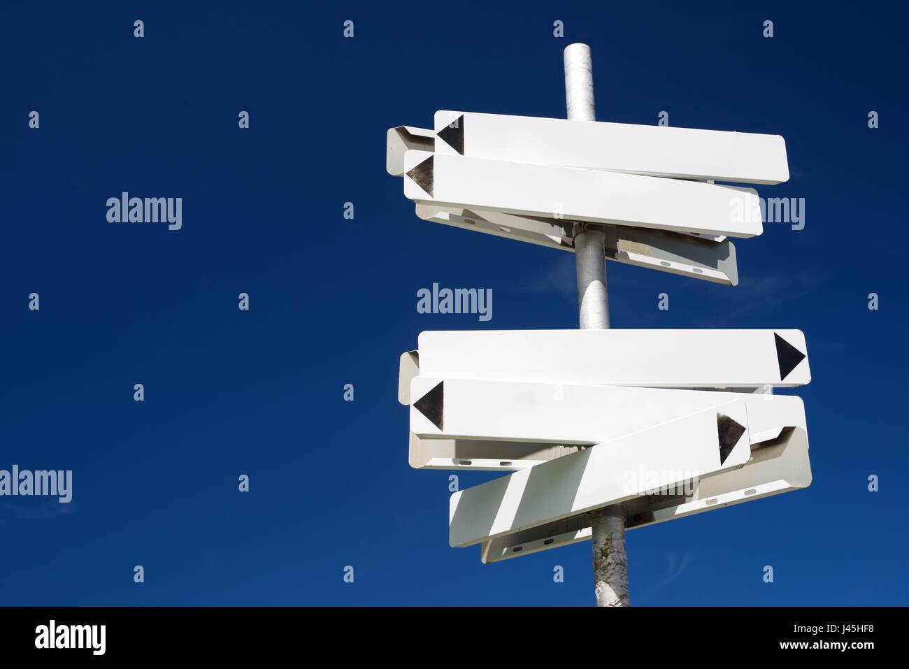 Directional signals in a pole with blue sky Stock Photo - Alamy