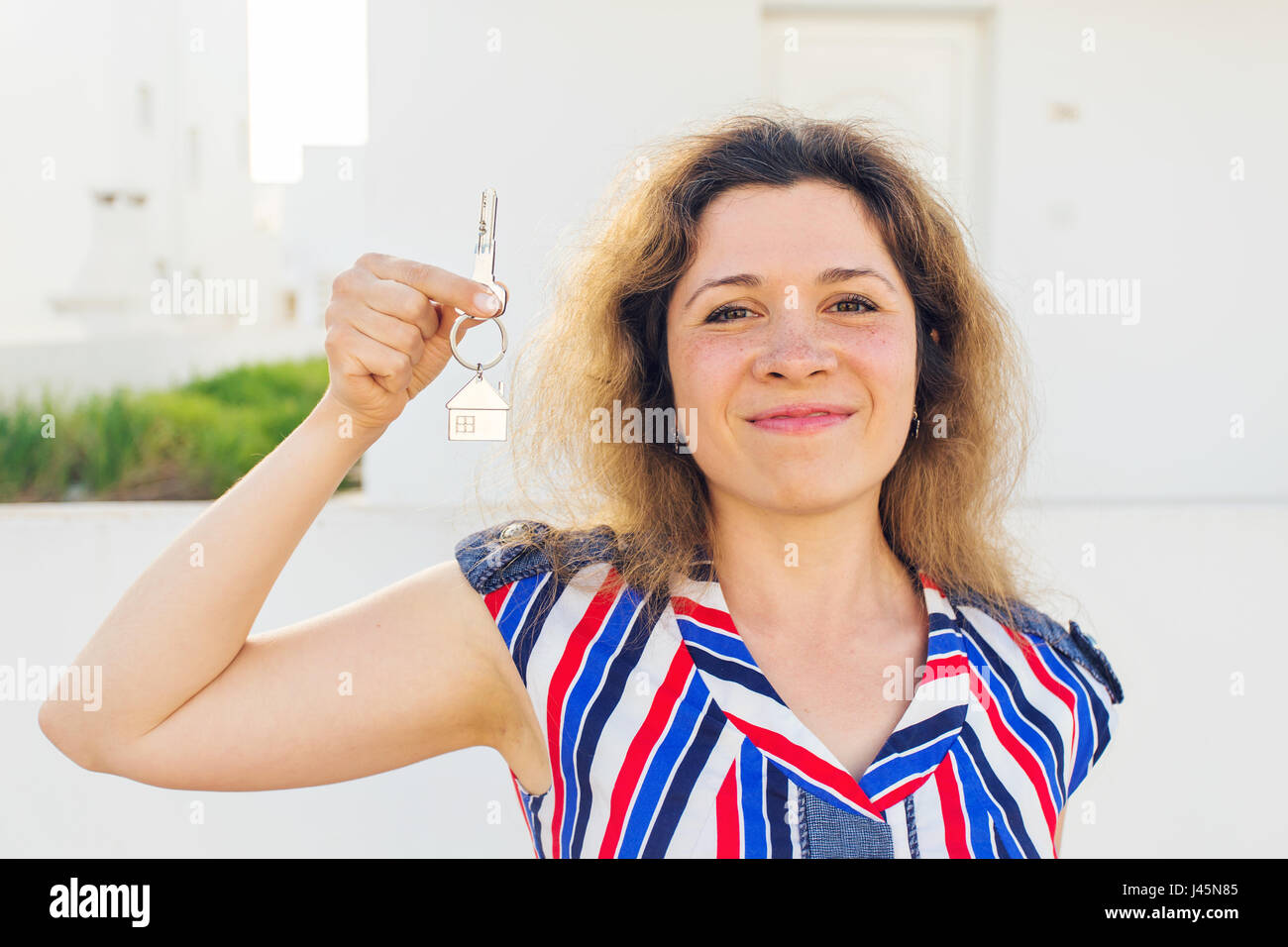 Close-up of happy house owner or renter showing keys and looking at you ...