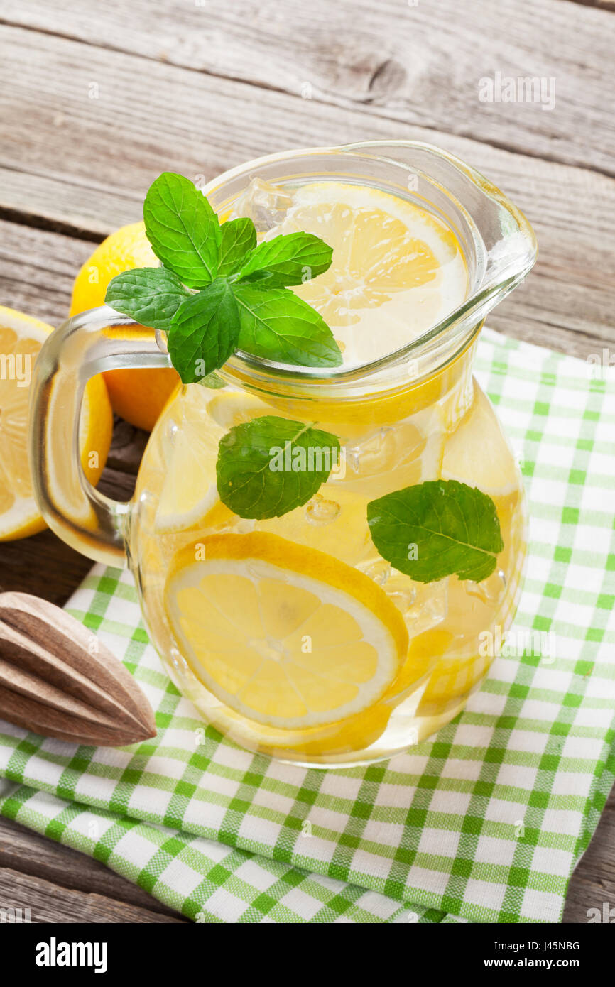 Lemonade pitcher with lemon, mint and ice on garden table Stock Photo ...
