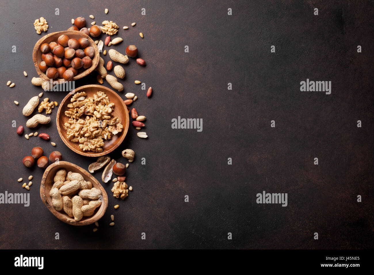 Various nuts on stone table. Top view with copy space Stock Photo - Alamy