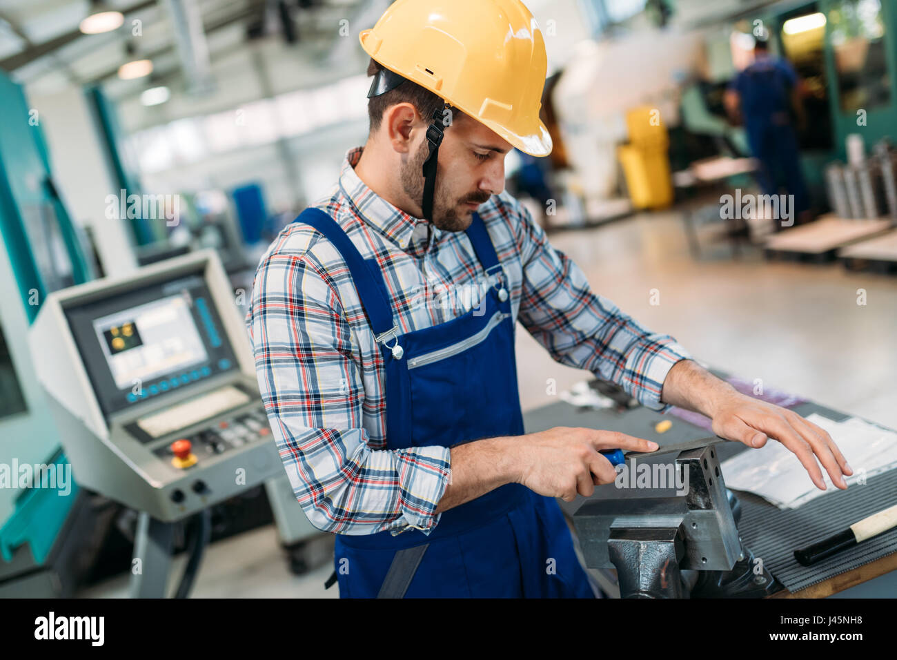 modern industrial machine operator working in metal industry factory ...
