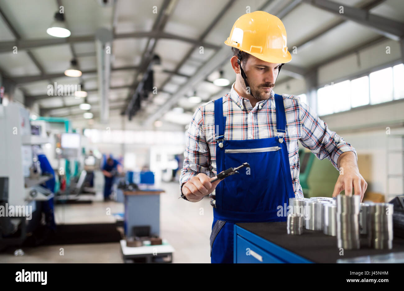 Male worker and quality control inspection in metal industry factory ...