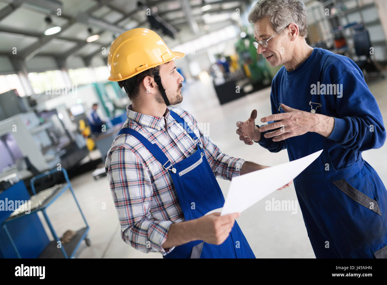 Portrait of an handsome engineer working in metal industry factory ...
