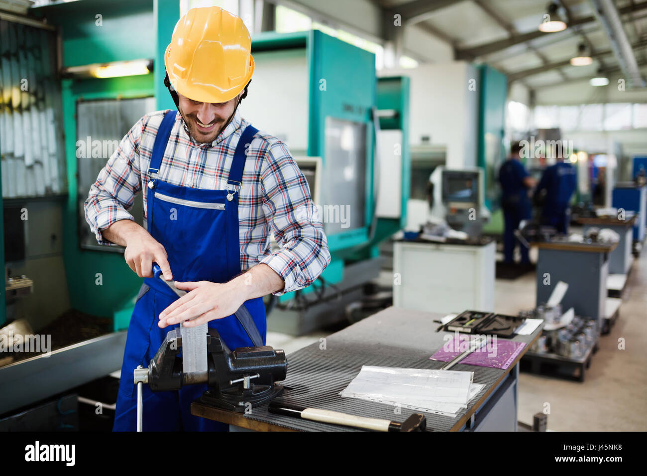 Portrait of an handsome engineer working in metal industry factory ...
