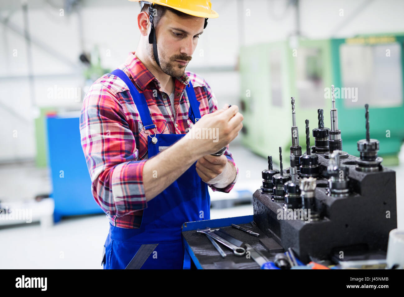 modern industrial machine operator working in metal industry factory ...