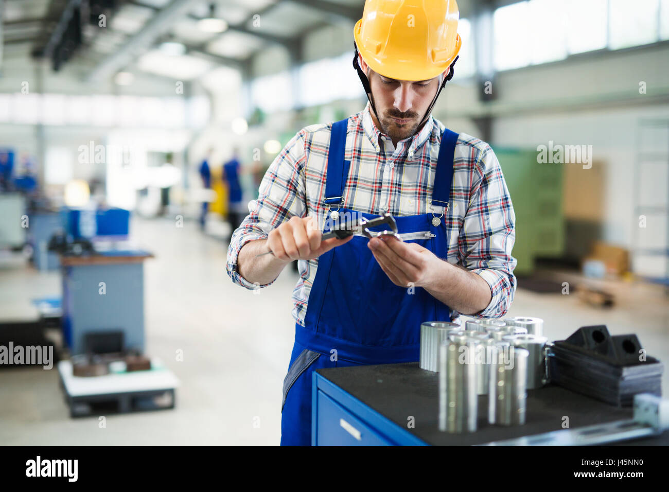 Portrait of an handsome engineer working in metal industry factory ...