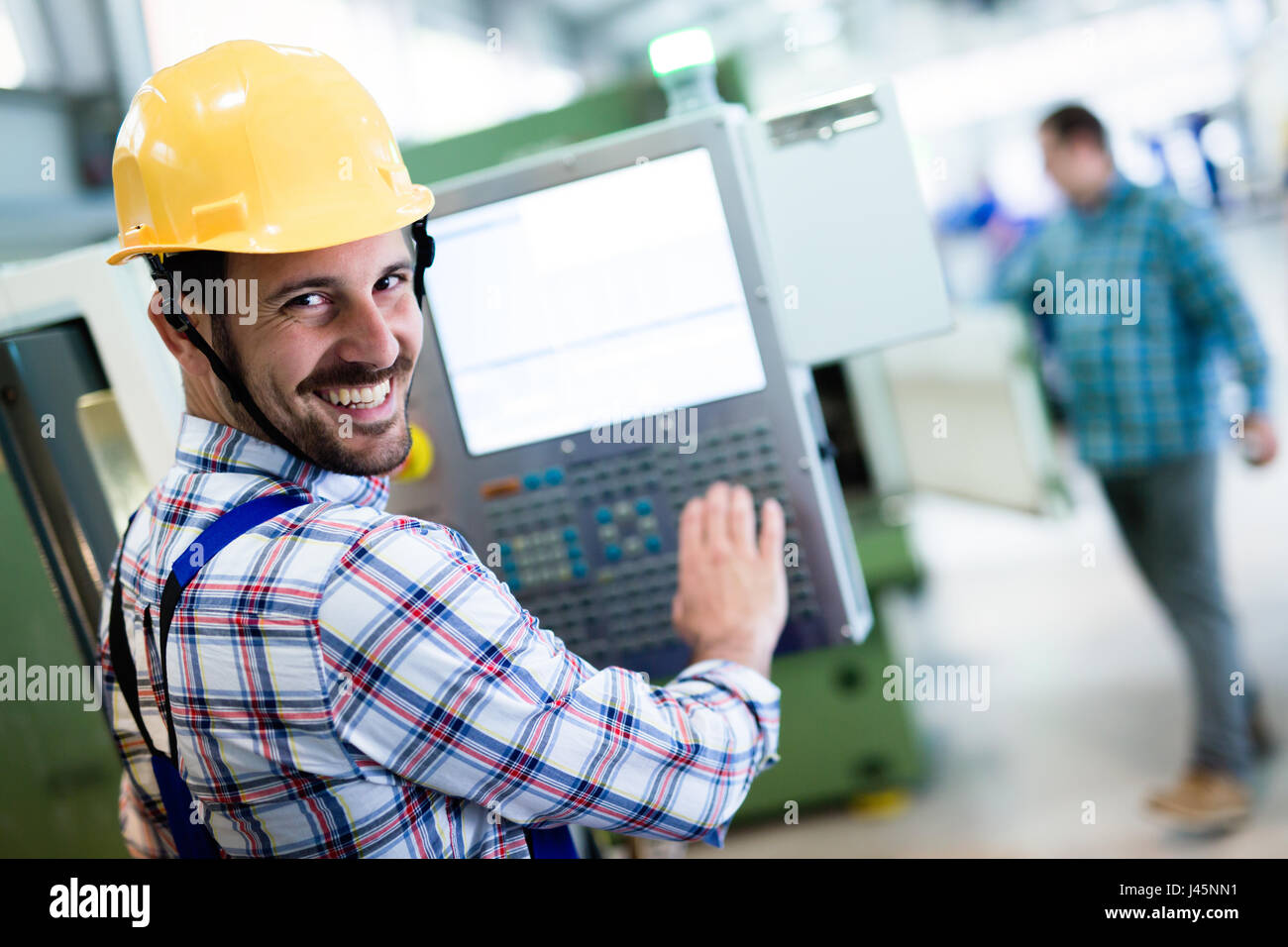 modern industrial machine operator working in metal industry factory ...