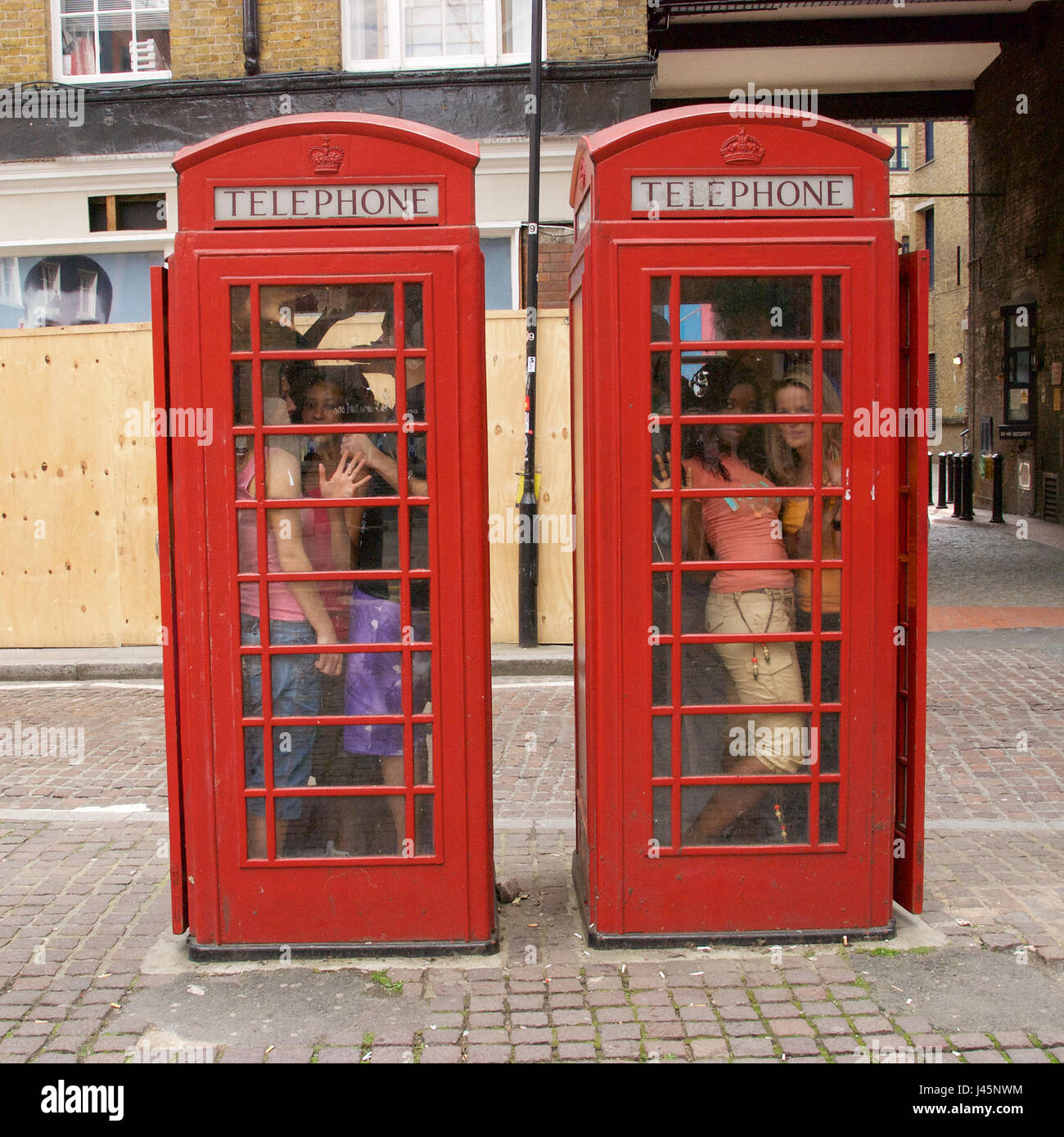 Group of dancers posing in telephone boxes in Old Brewers Yard, London ...