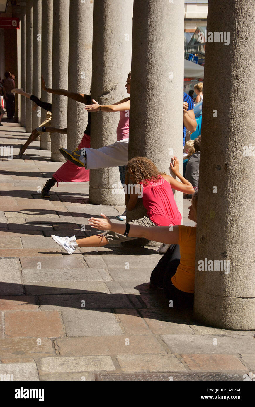 Group of dancers posing against and behind columns of a building in ...