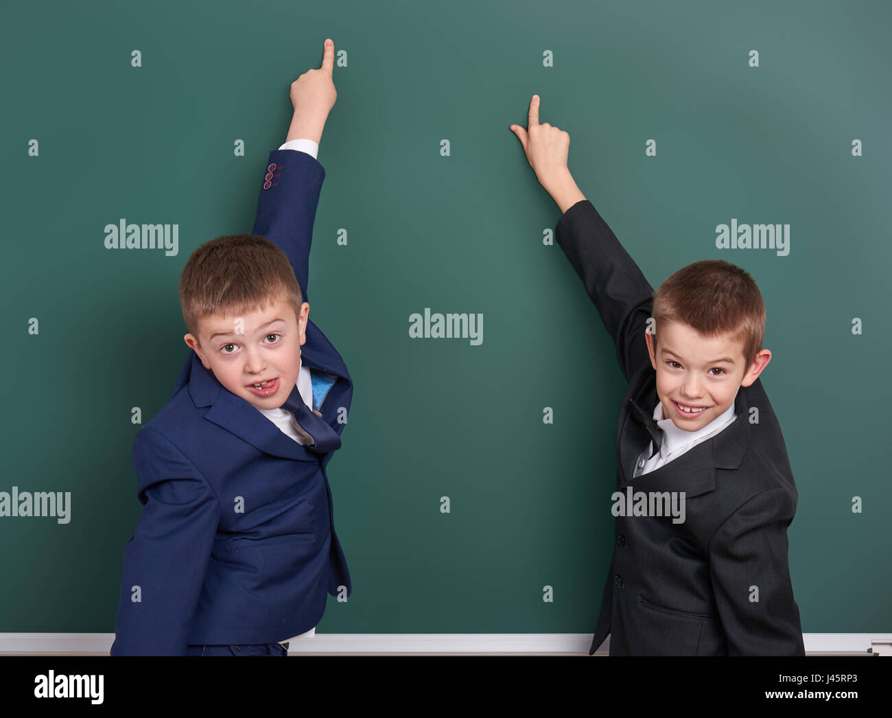 school boy point finger at blank chalkboard background, dressed in ...