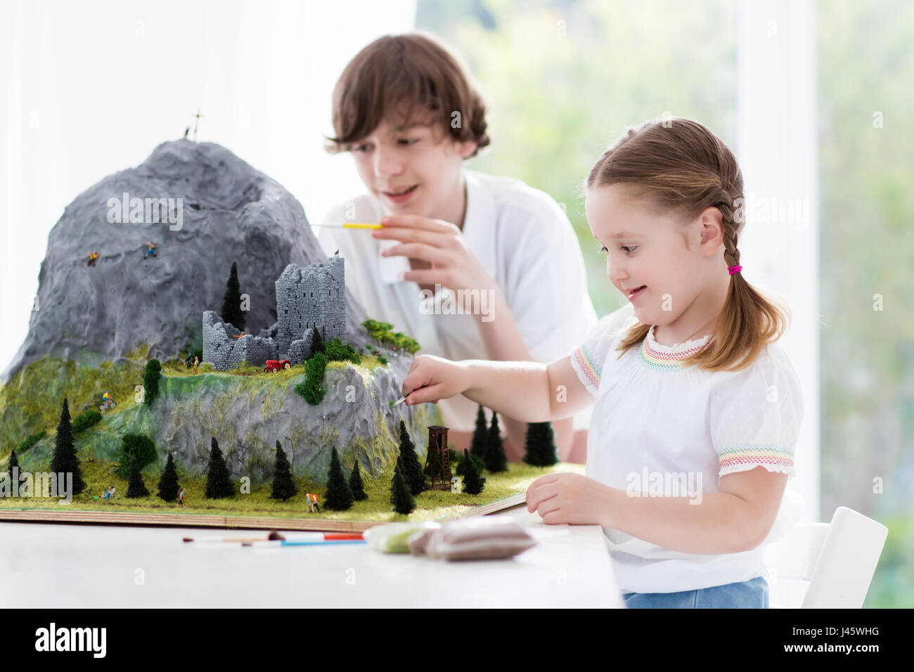 Children work on model building school project. Kids build miniature ...